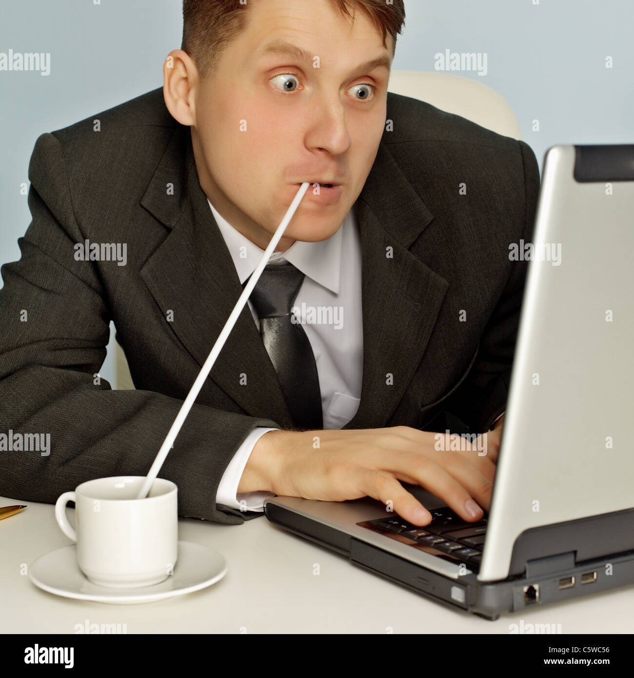 Funny businessman drinking hot coffee and working on the Internet Stock ...