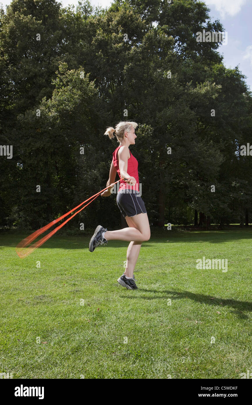 Germany, Berlin, Young woman jumping rope in park Stock Photo - Alamy