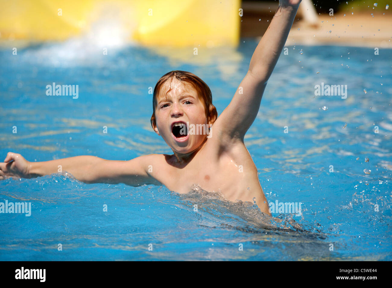 Boy splashing in swimming pool hi-res stock photography and images - Alamy