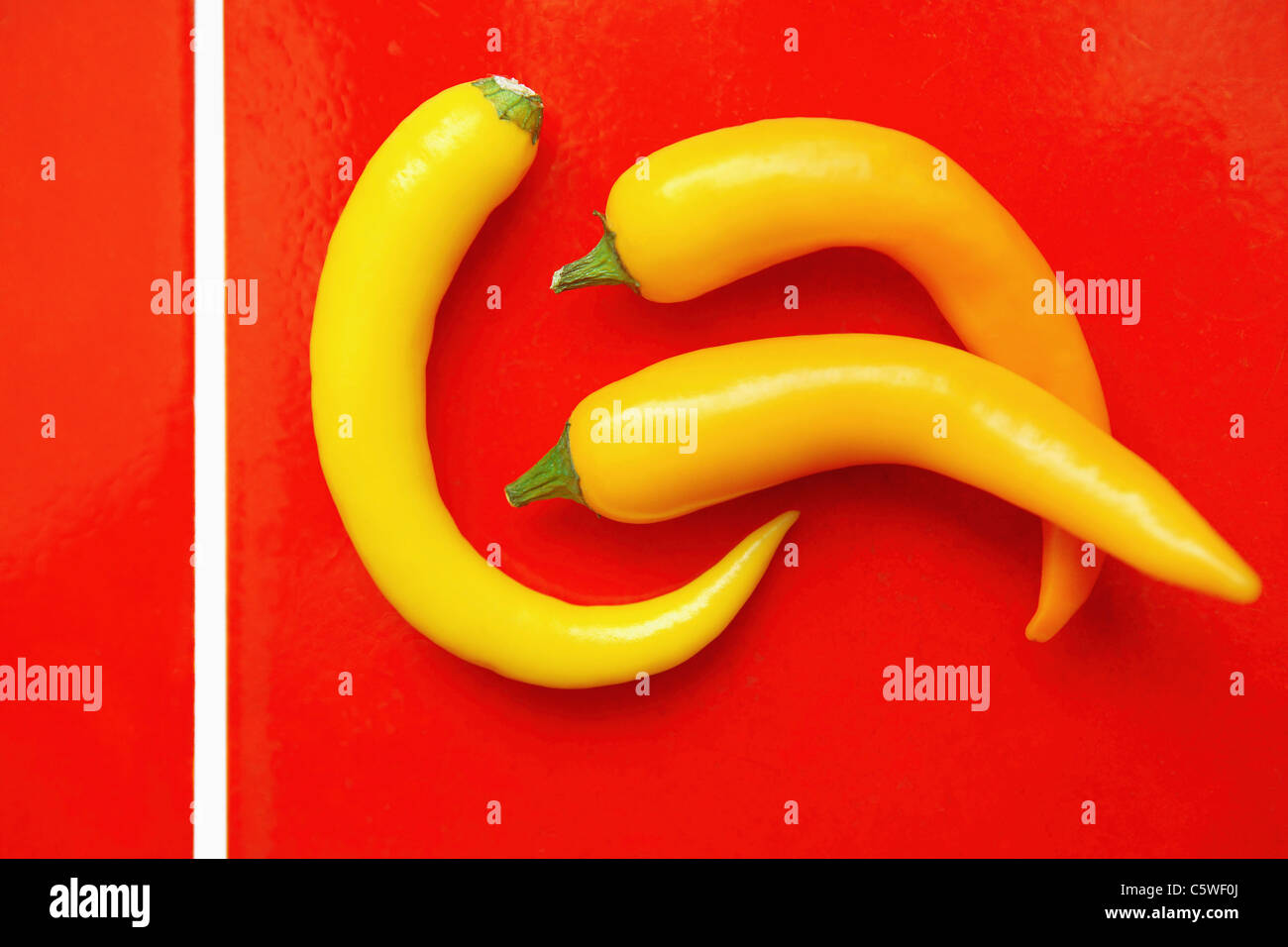 Yellow chili pods on red tiles, elevated view Stock Photo - Alamy