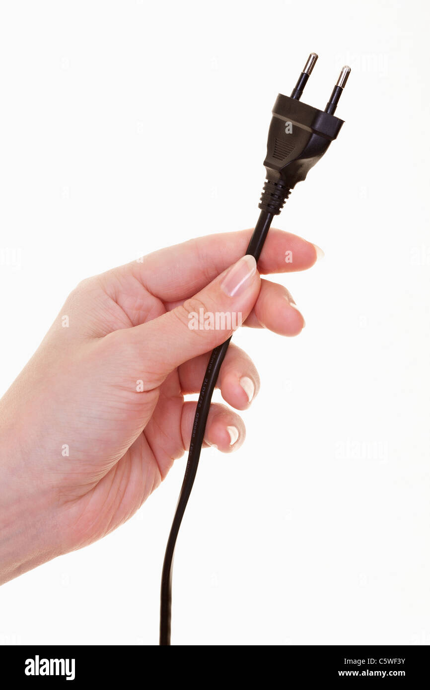 Hand of woman holding power cable against white background, close up ...