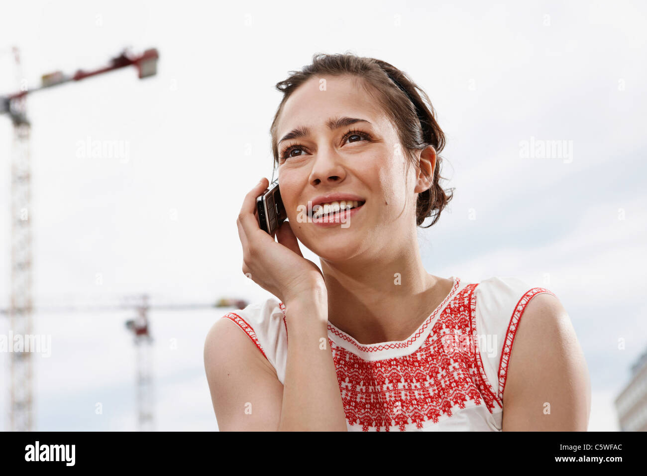 Germany, Berlin, Young woman using mobile phone, portrait, close-up ...