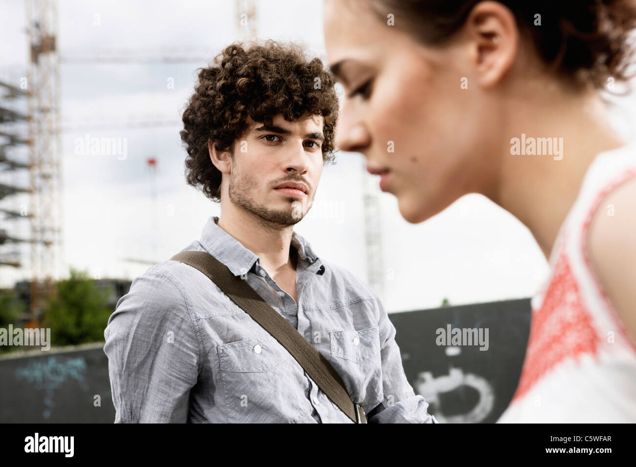 Germany, Berlin, Young couple, woman looking down, side view, portrait ...