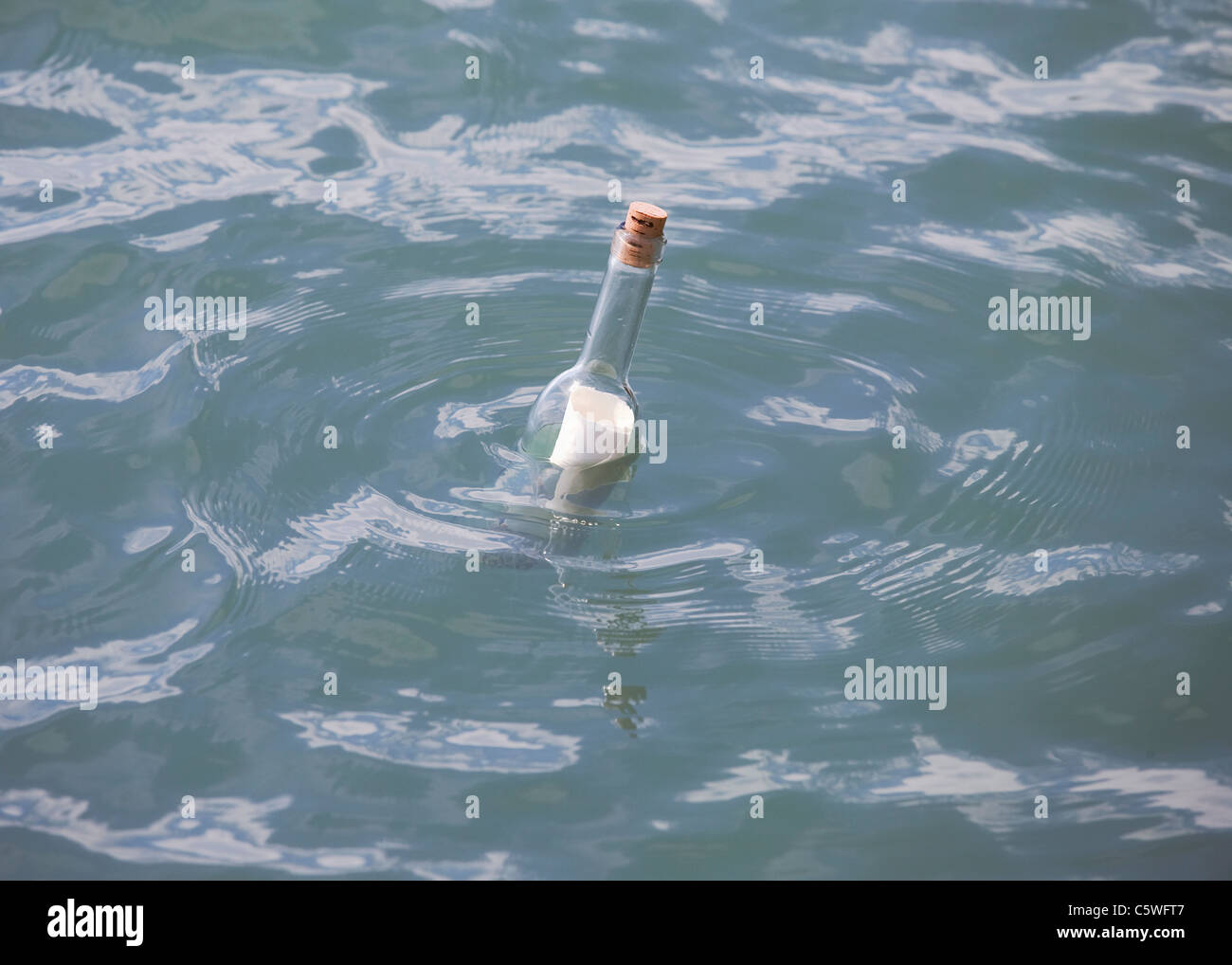 Germany, Message in bottle floating in sea Stock Photo - Alamy