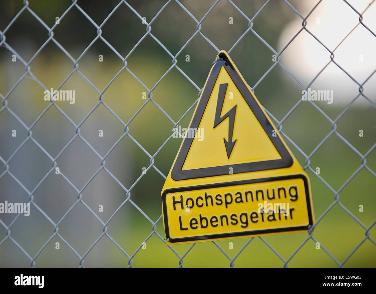 Germany, Yellow warning sign on fence Stock Photo - Alamy