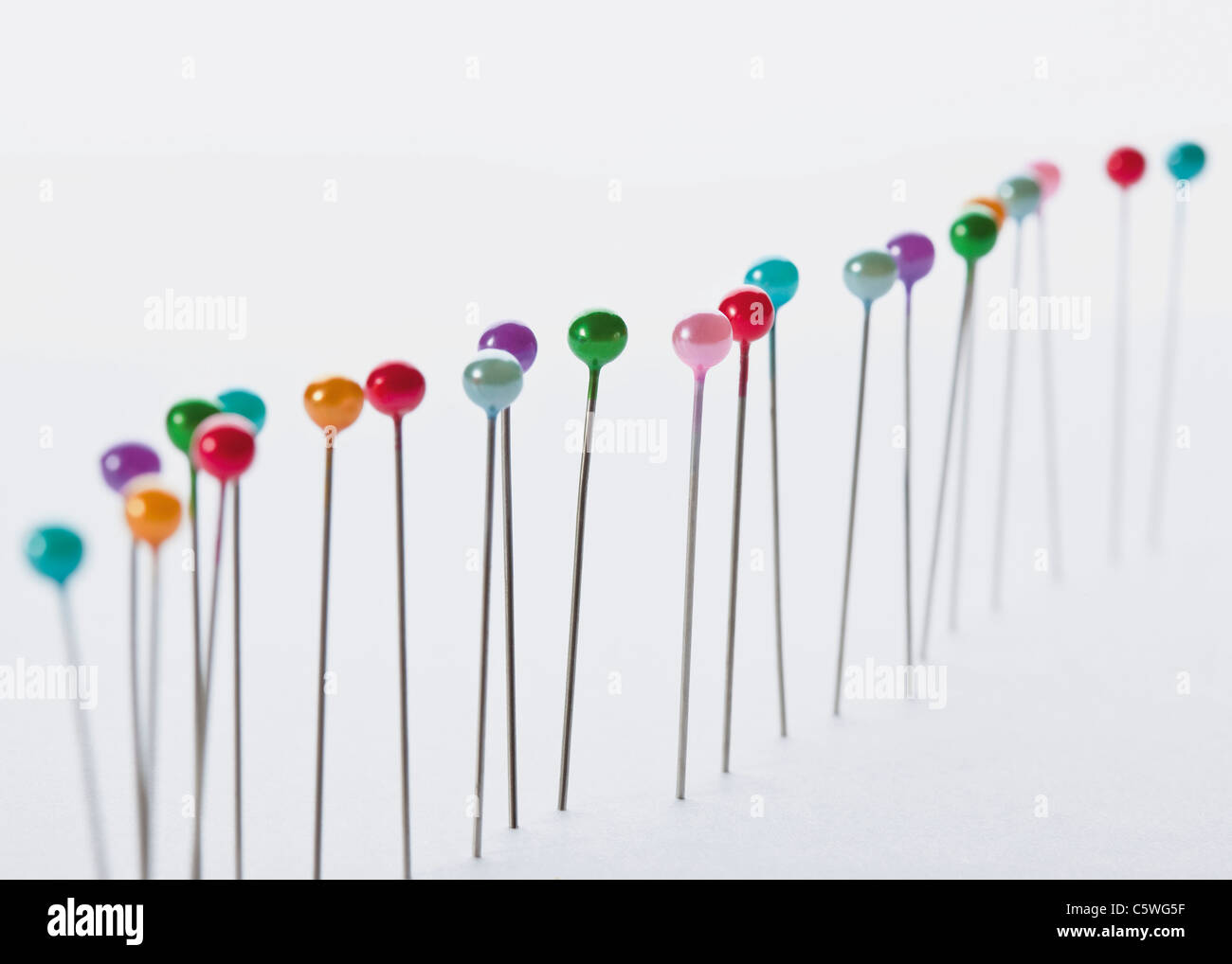 Row of pins on white background Stock Photo - Alamy