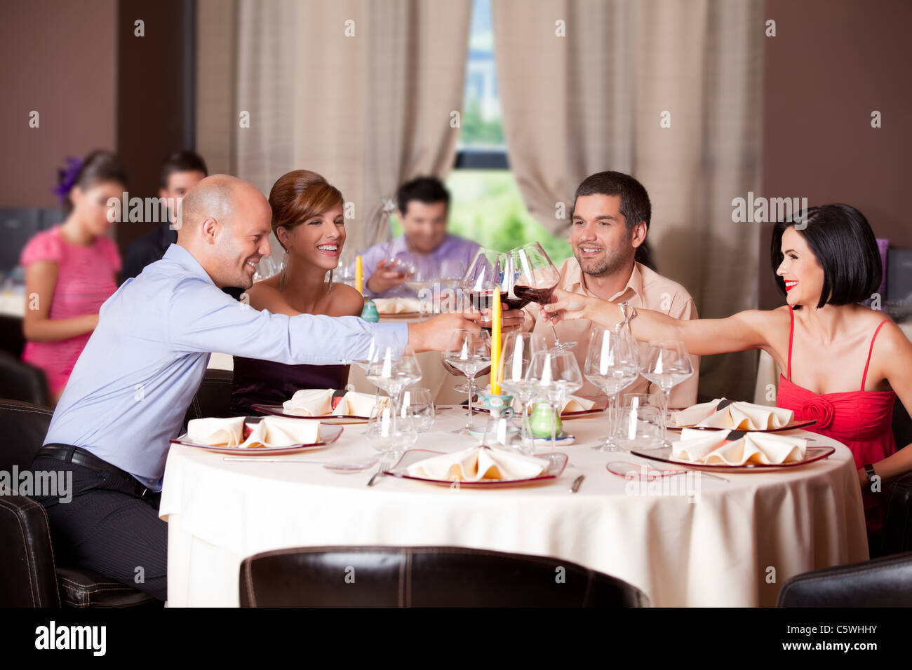 happy young couples toasting restaurant table Stock Photo - Alamy