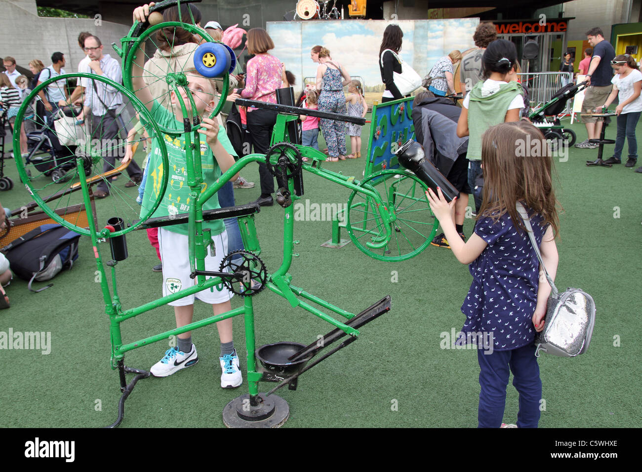 UK. Children play with toys made of recycled materials in a playground ...