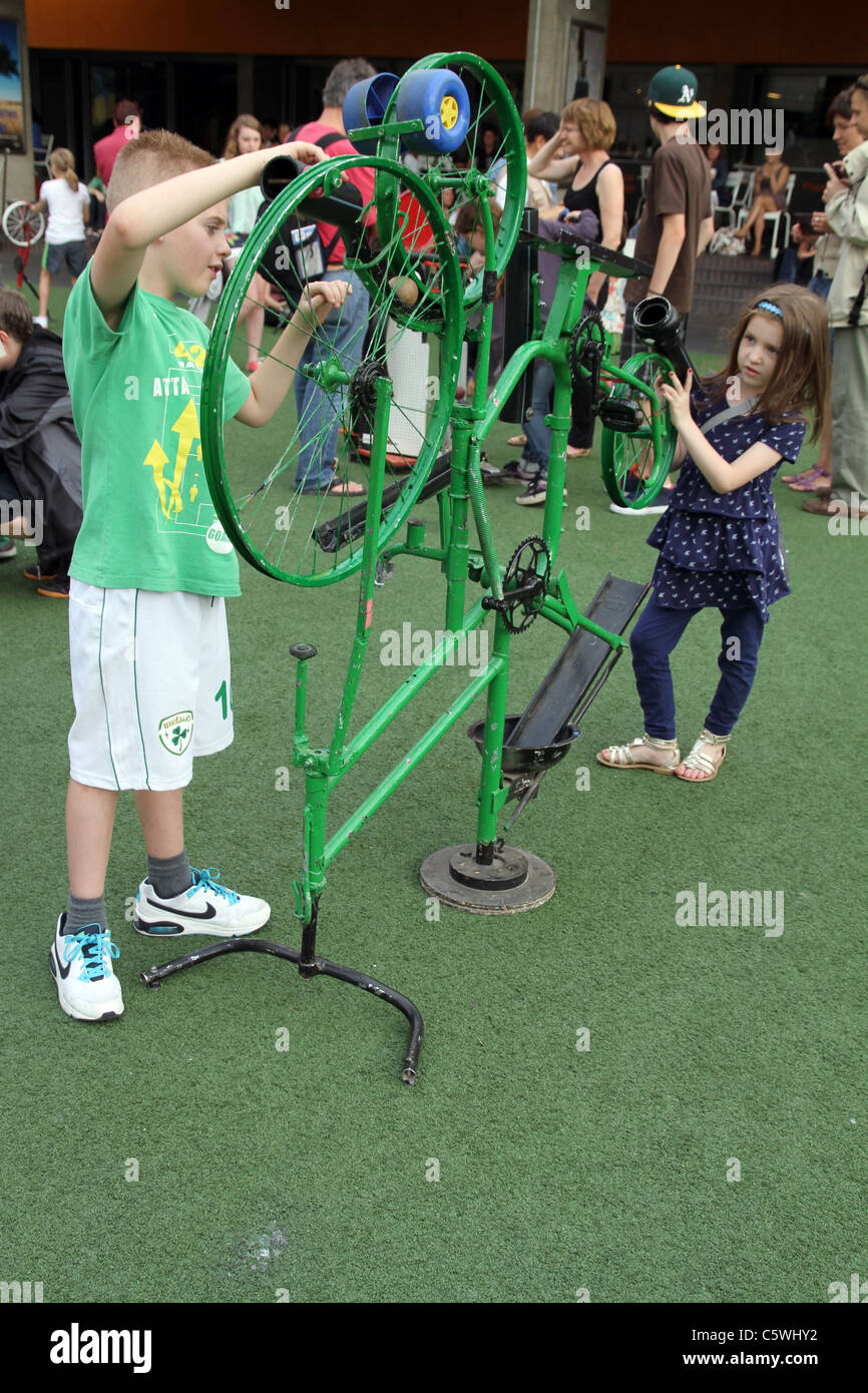 UK. Children play with toys made of recycled materials in a playground ...