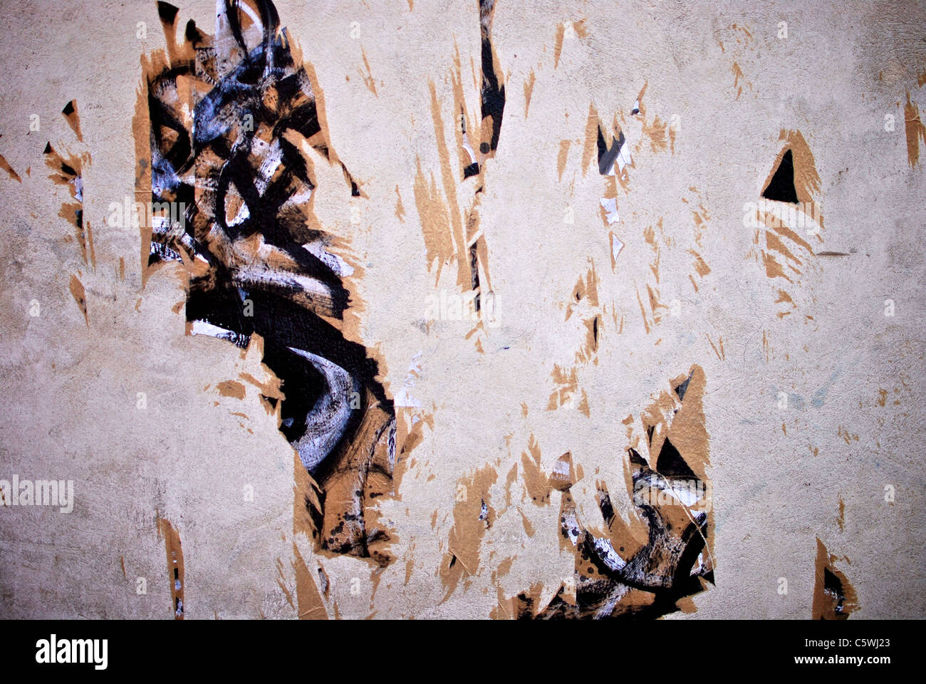 Shredded remains of an advertising bill poster on a wall in Arles ...