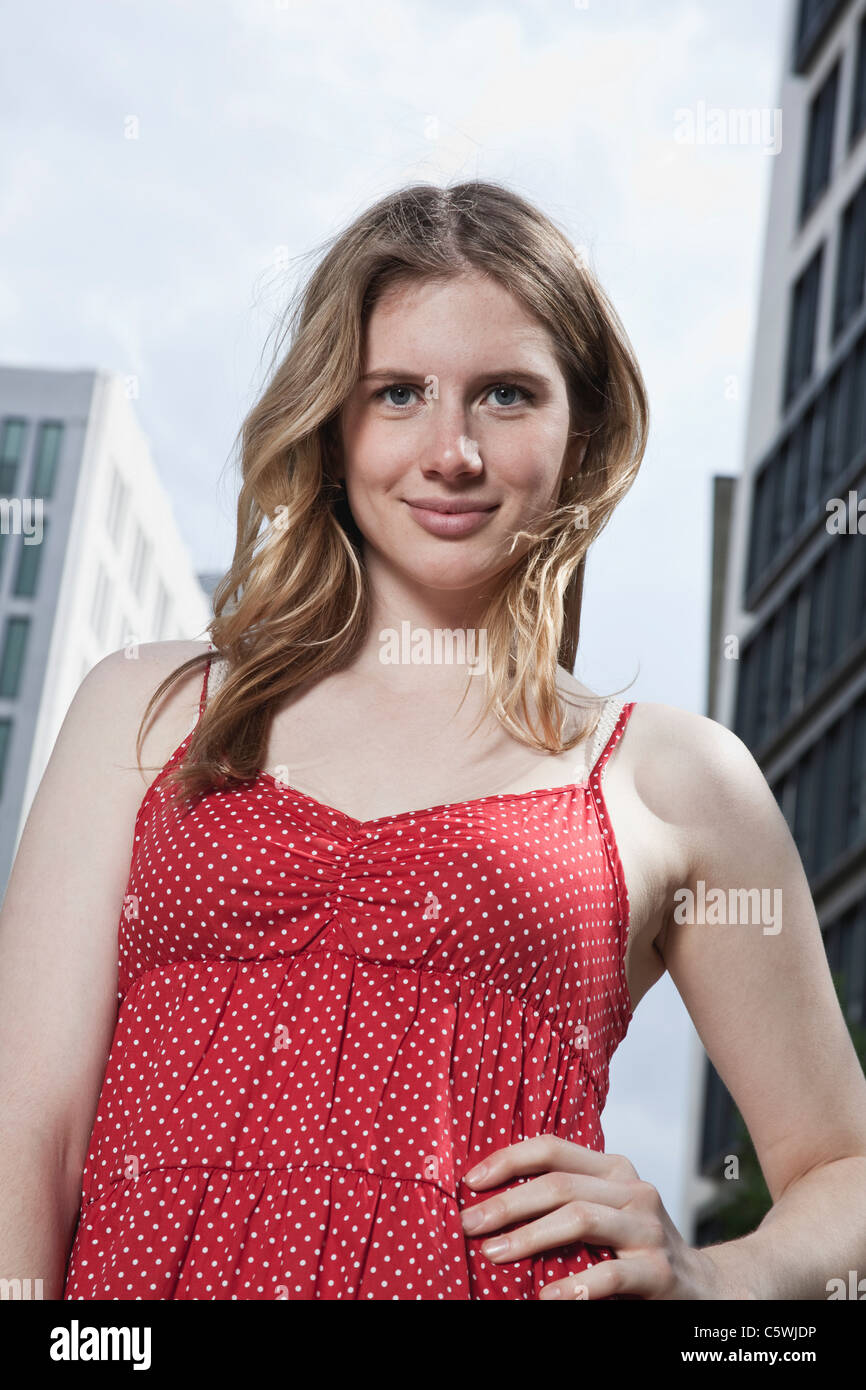 Germany, Berlin, Woman standing and smiling, portrait Stock Photo - Alamy