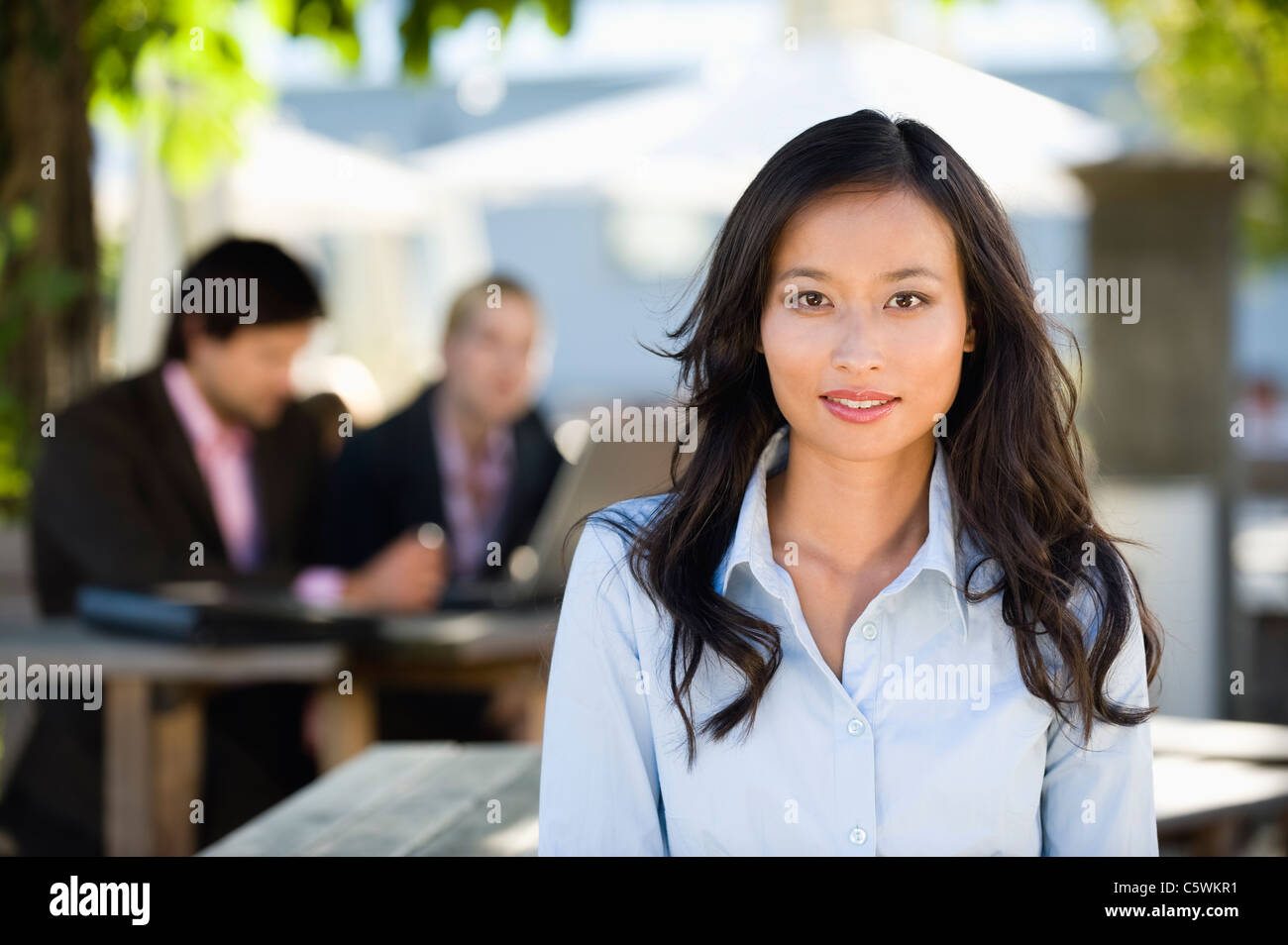 Germany, Bavaria, Upper Bavaria, Asian woman in beer garden, portrait ...