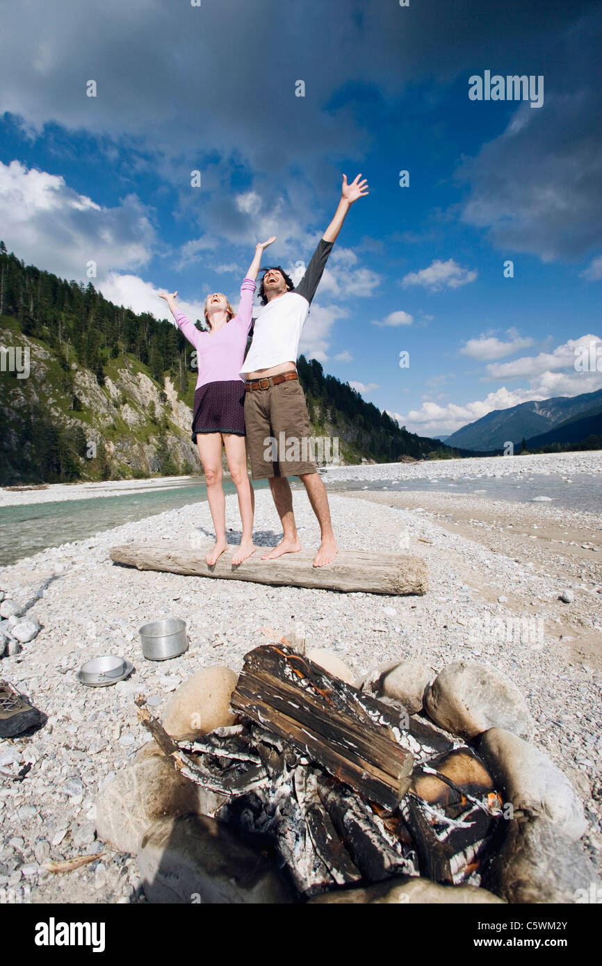 Germany, Bavaria, TÃ¶lzer Land, Young couple standing on tree trunk ...