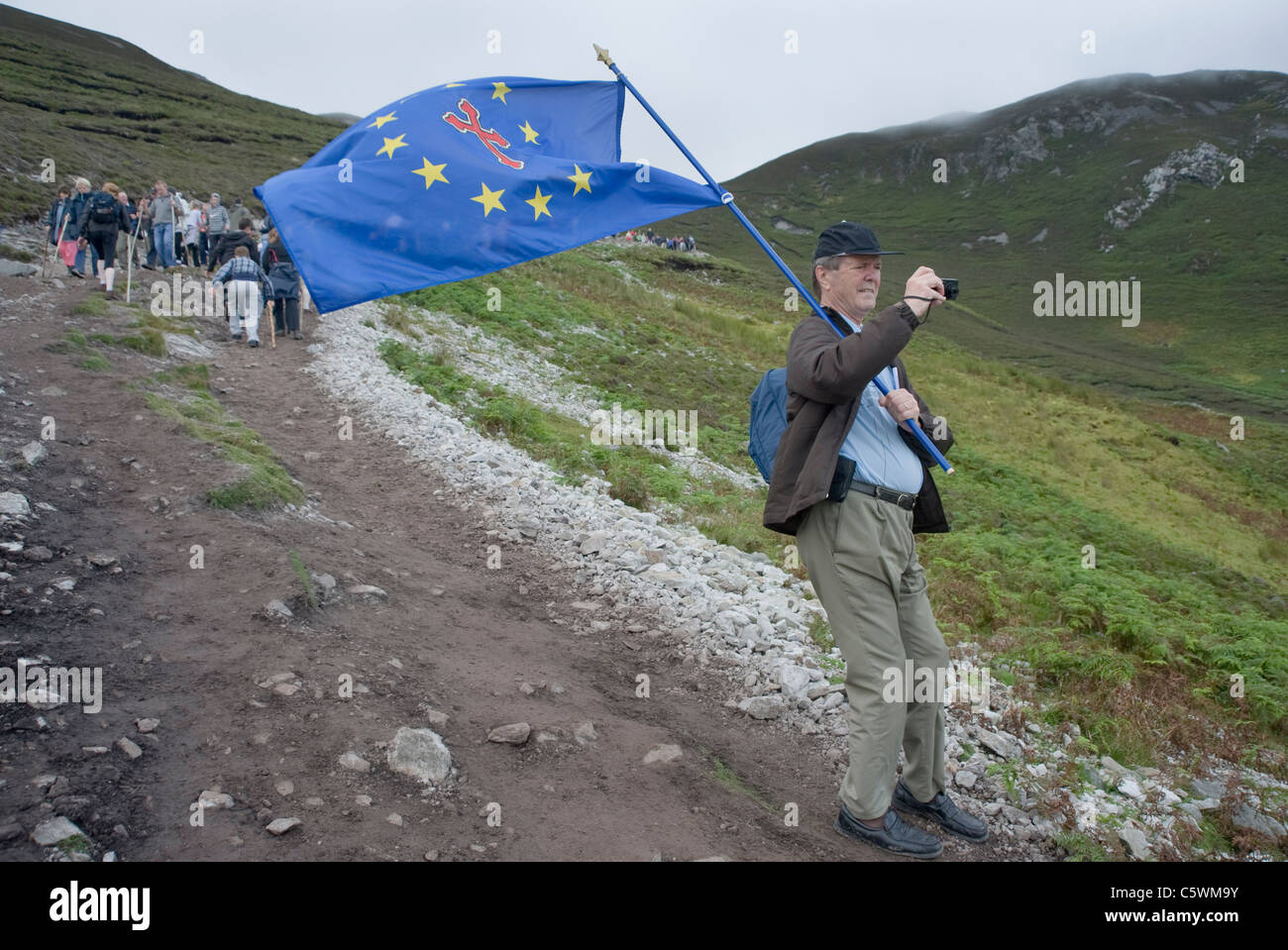 A French pilgrim takes a photograph on the ascent of Croagh Patrick ...
