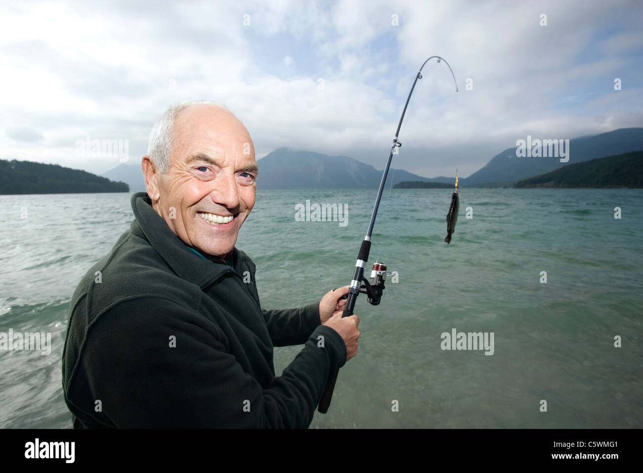 Germany, Bavaria, Walchensee, Senior man fishing in lake Stock Photo ...