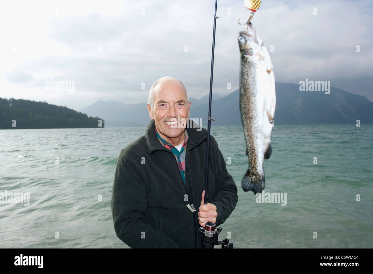 Germany, Bavaria, Walchensee, Senior man fishing in lake Stock Photo ...