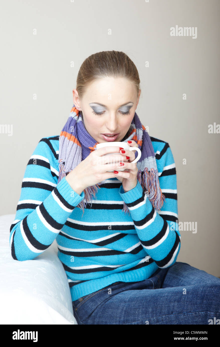 Sick woman drinking hot tea. Indoors photo Stock Photo - Alamy