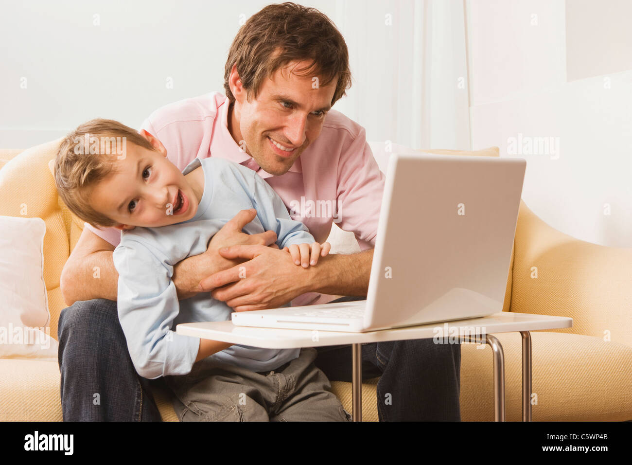Father and son (4-5) using laptop Stock Photo - Alamy