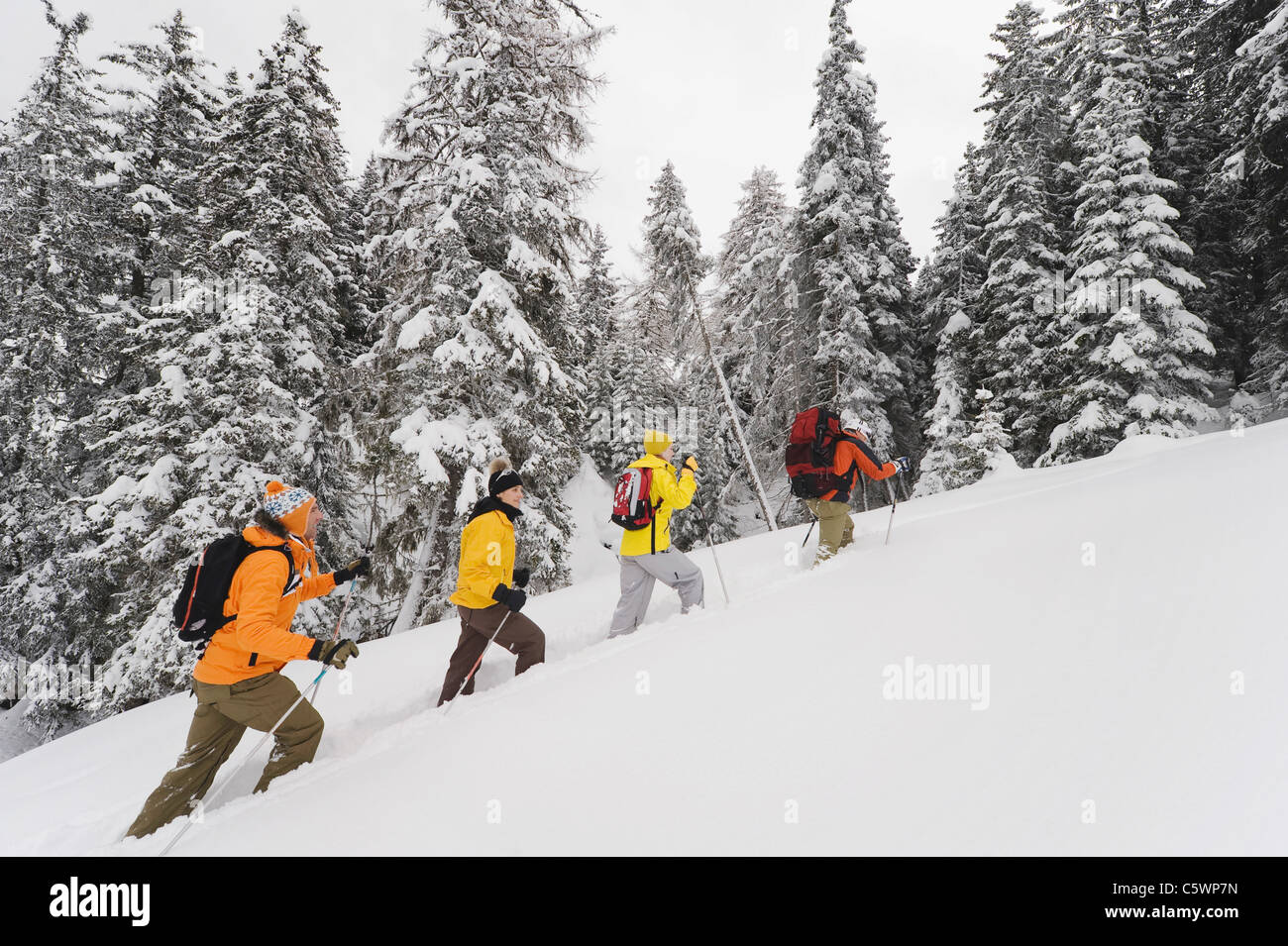 Italy, South Tyrol, People in winter clothes hiking uphill Stock Photo ...