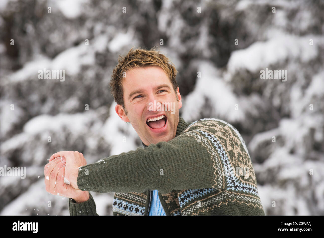 Italy, South Tyrol, Young man with snowball, laughing, portrait Stock ...