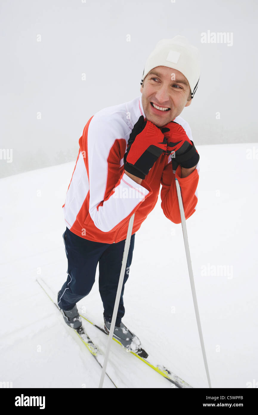 Italy, South Tyrol, Man with skis, resting head on ski sticks Stock ...