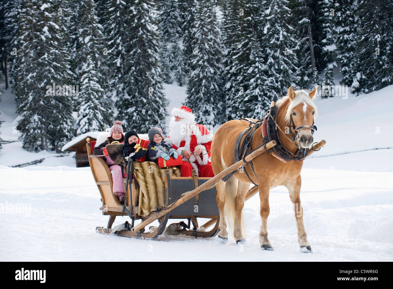 Italy, South Tyrol, Seiseralm, Santa Claus and children taking a sleigh ...