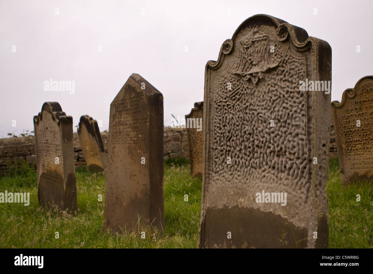 Eroded gravestones and tombs in the churchyard of St Mary's Church in ...