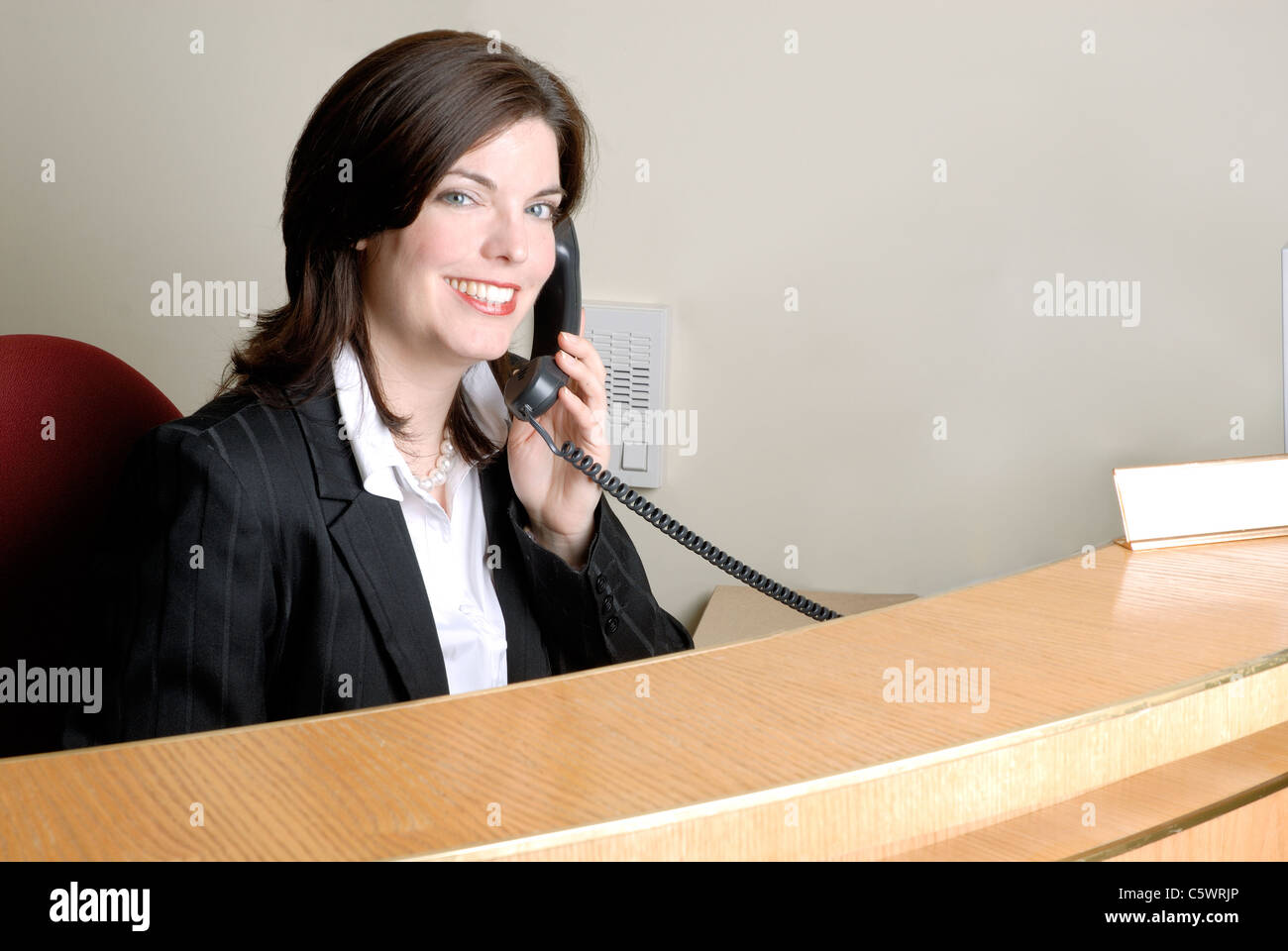 Attractive Brunette Young Woman Answering The Phone At A Company ...