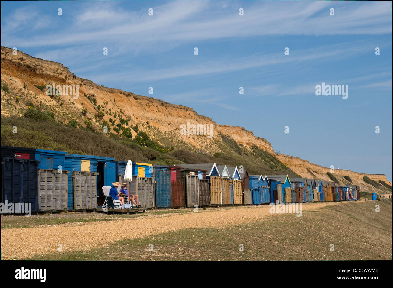 A line of beach huts sit beneath the cliffs at Highcliff, Hampshire on ...