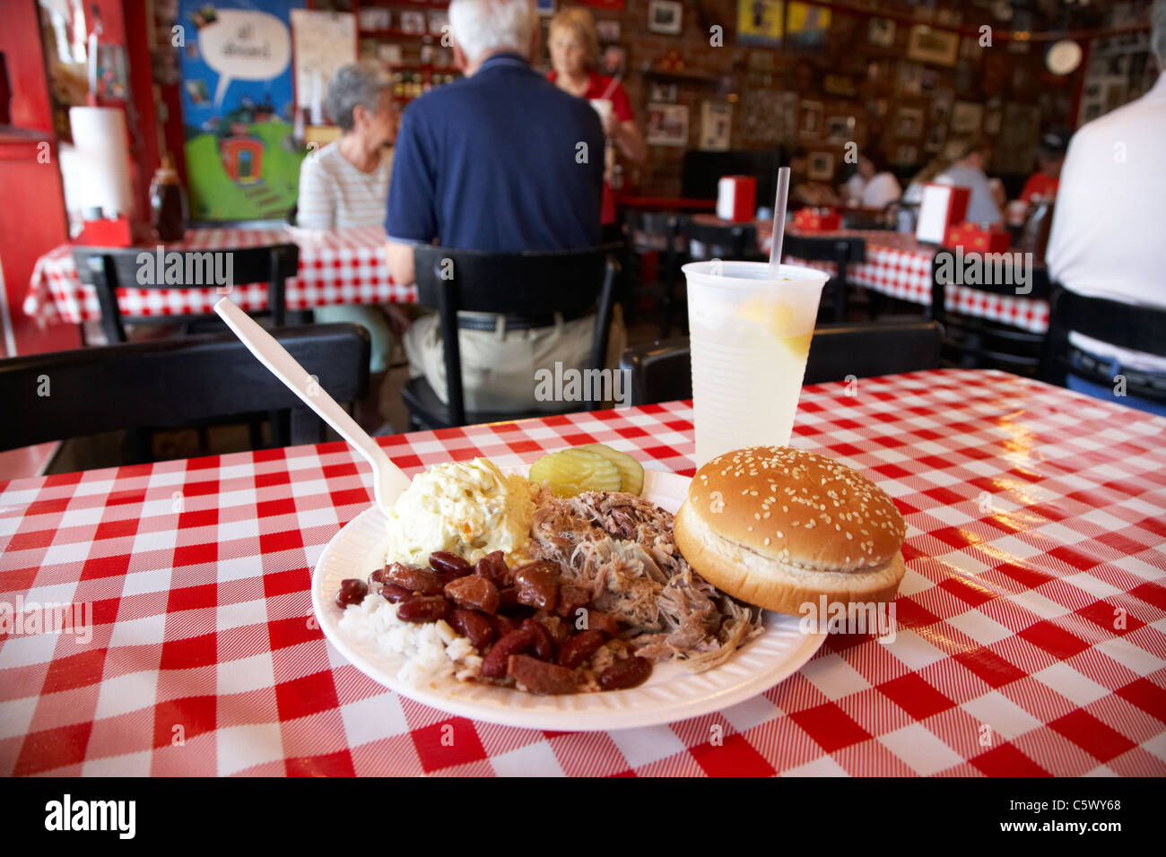 pulled pork bbq platter on cafe table served with disposable plates and ...