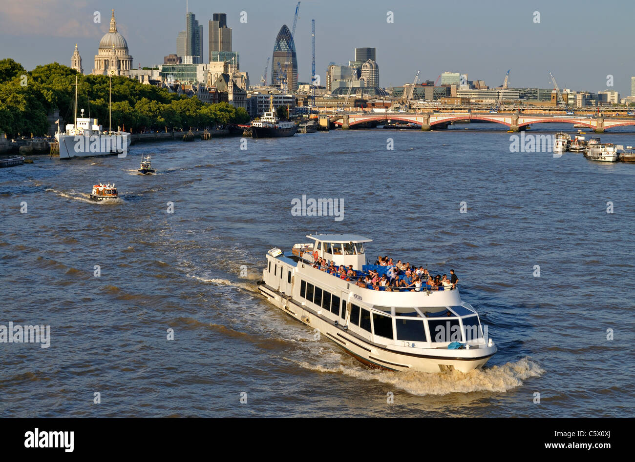 A sightseeing boat making its way down the River Thames in the City of ...