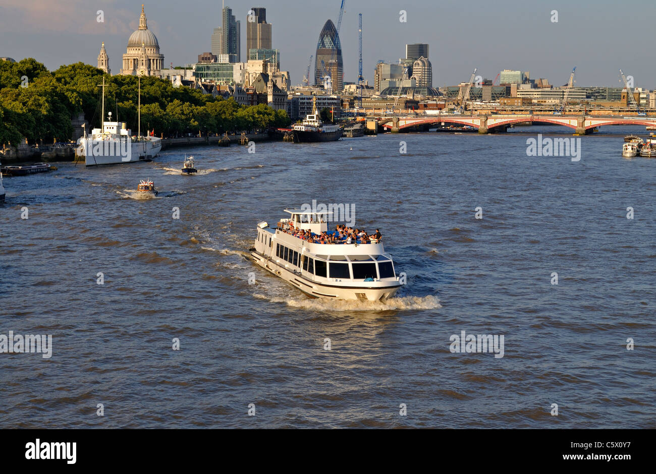 A sightseeing boat making its way down the River Thames in the City of ...