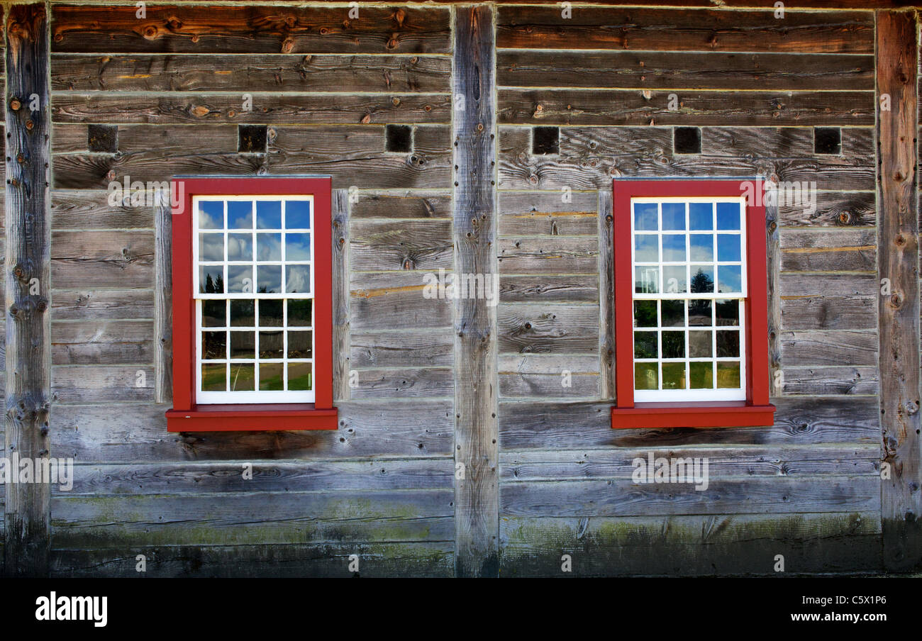 Two Old red and white windows on a vintage wood wall reflecting a blue ...