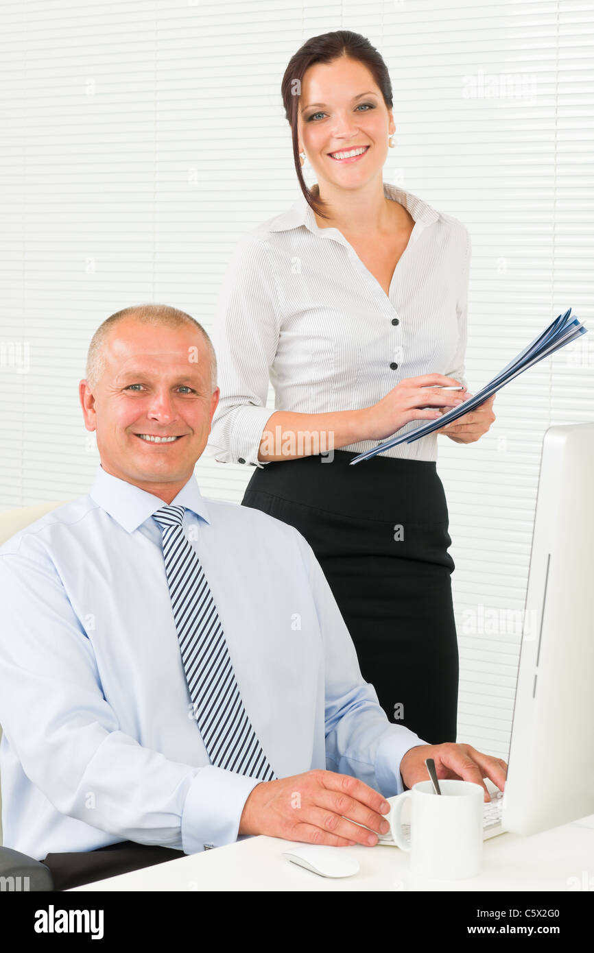 Professional senior businessman sitting in office with woman secretary ...