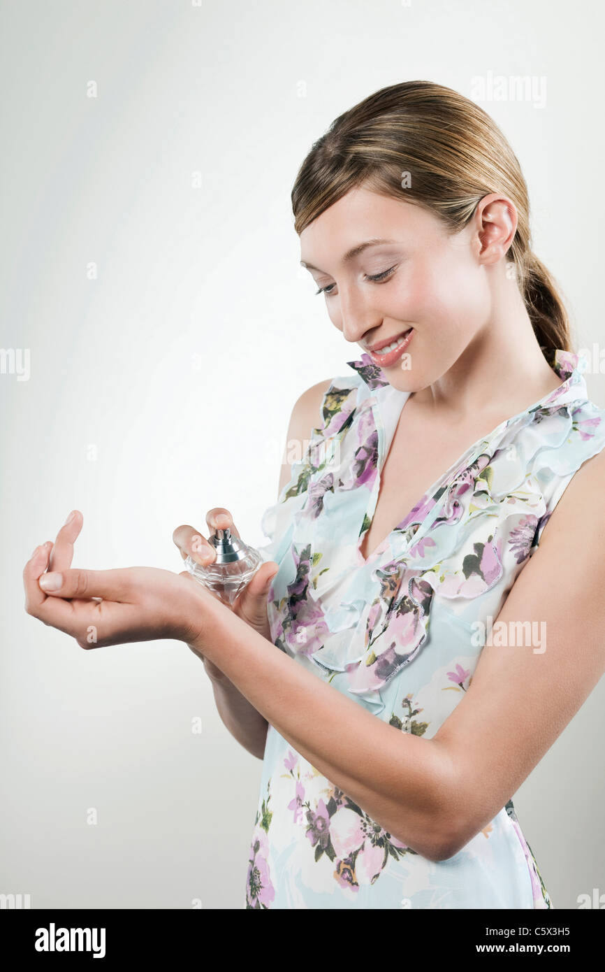 Young woman applying perfume on her wrist, portrait Stock Photo - Alamy