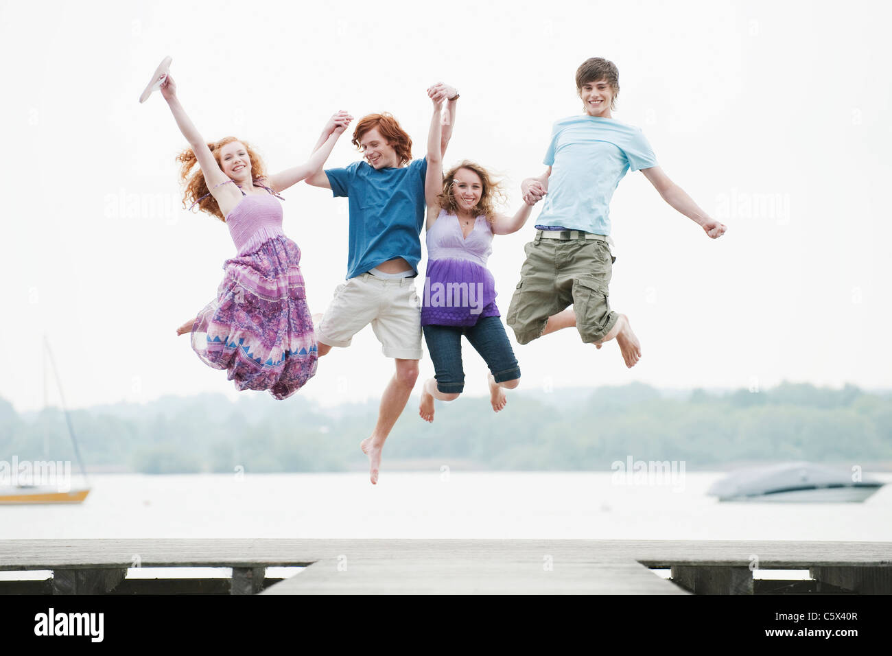 Teenage boy jumping over friends hi-res stock photography and images ...