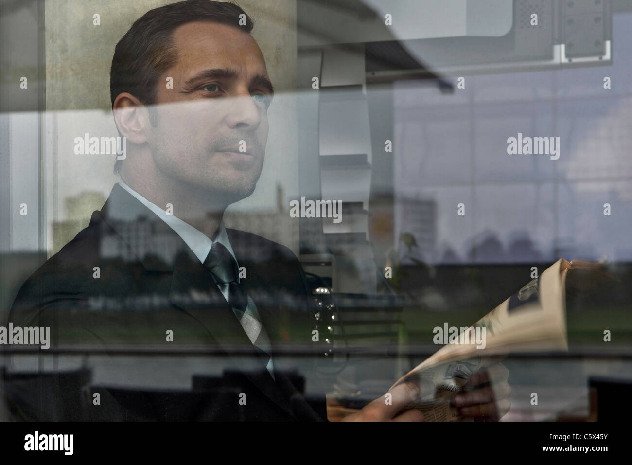 Germany, Cologne, Business man sitting in cafe, holding newspaper Stock ...