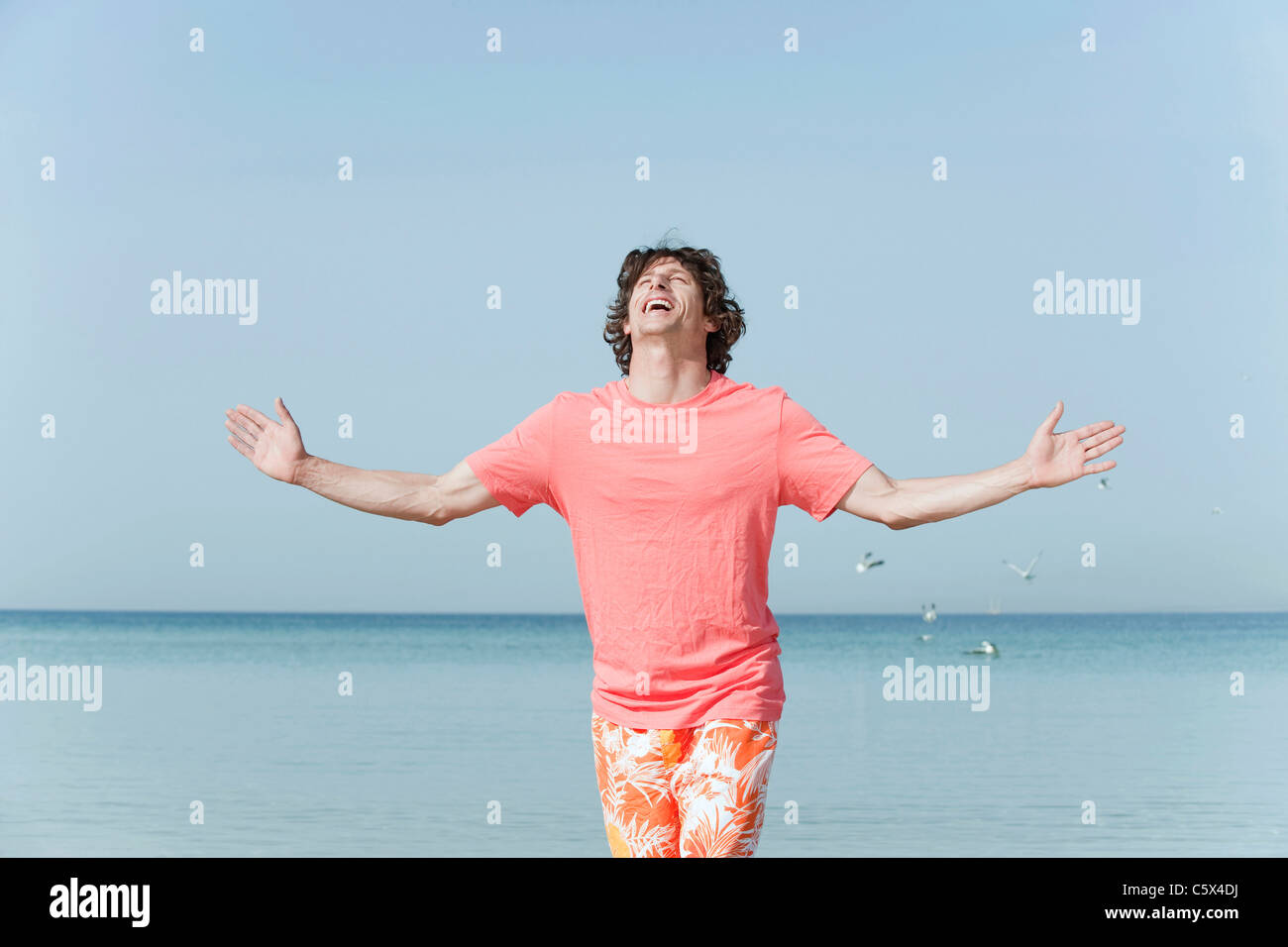 Spain, Mallorca, Man with arms outstretched at beach Stock Photo - Alamy