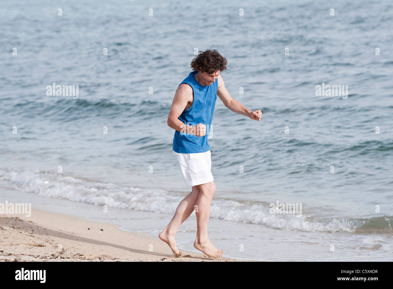 Spain, Mallorca, Man jogging on beach Stock Photo - Alamy