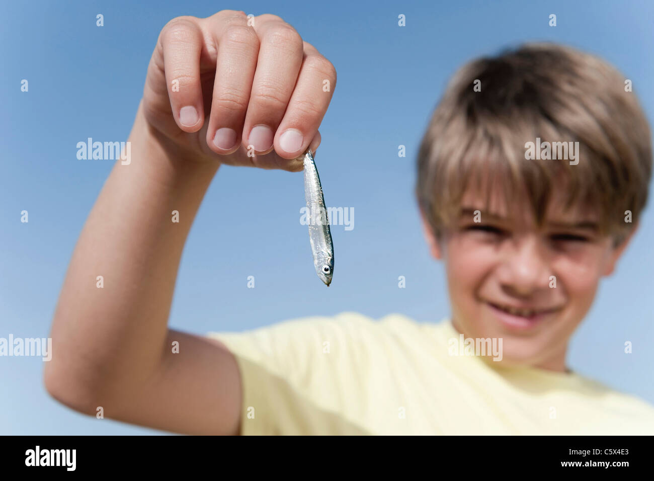 Boy (8-9) holding small fish, close-up Stock Photo - Alamy