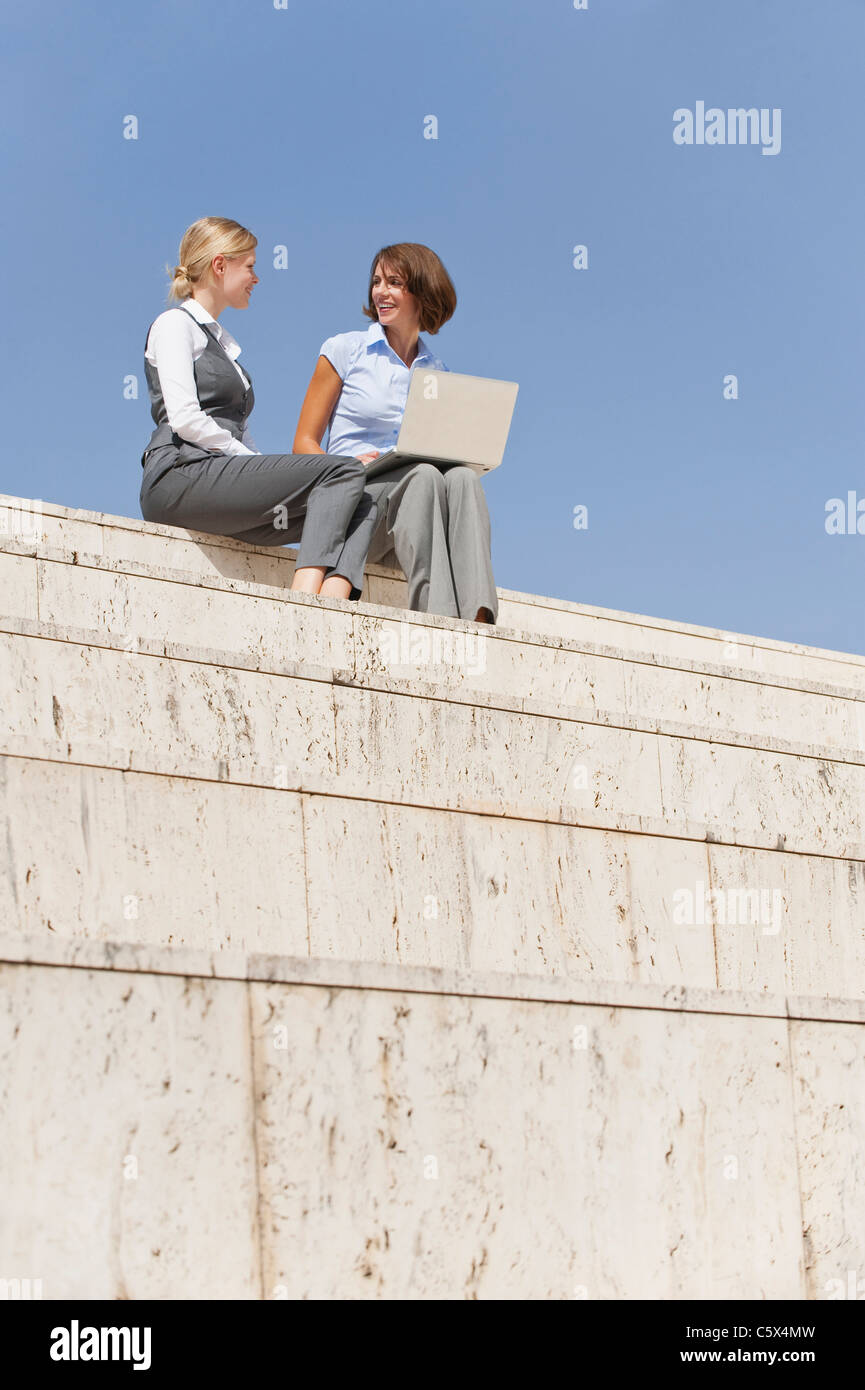 Spain, Mallorca, Two Businesswomen sitting on stairs using laptop Stock ... Spain, Mallorca, Two Businesswomen sitting on stairs using laptop Stock ...