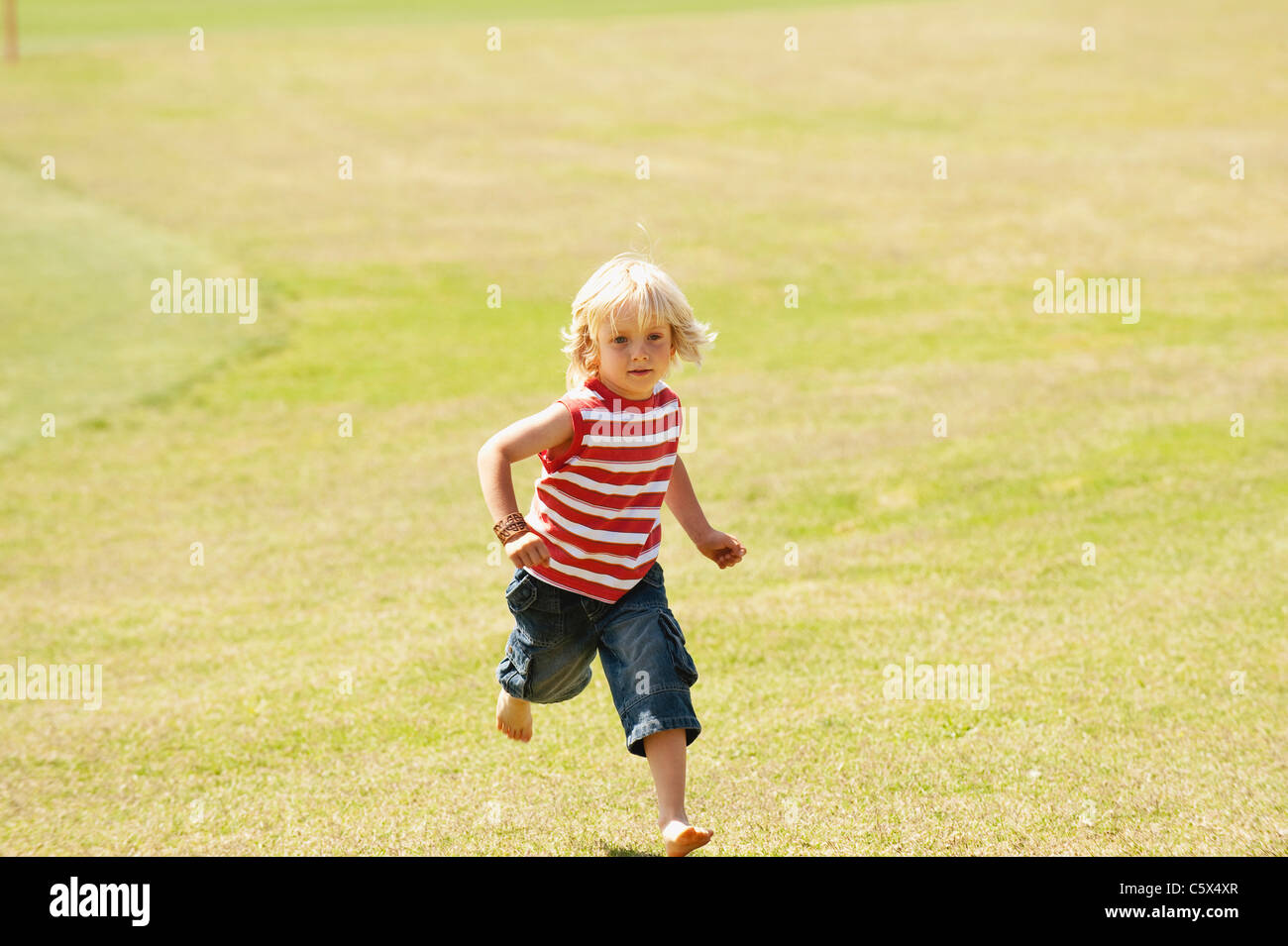 Spain, Mallorca, Boy (3-4) running across meadow Stock Photo - Alamy