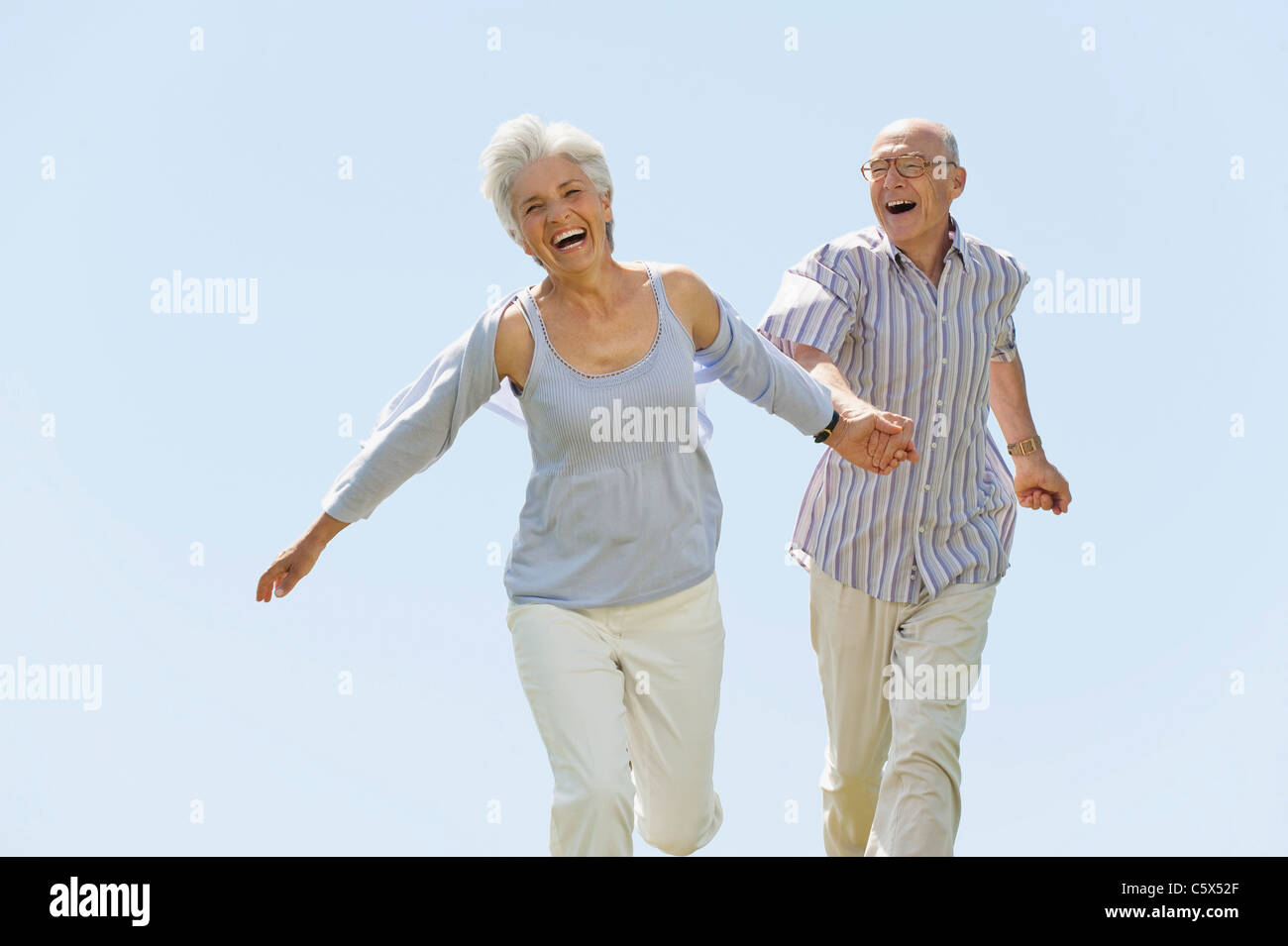 Senior couple running hand in hand, portrait Stock Photo - Alamy