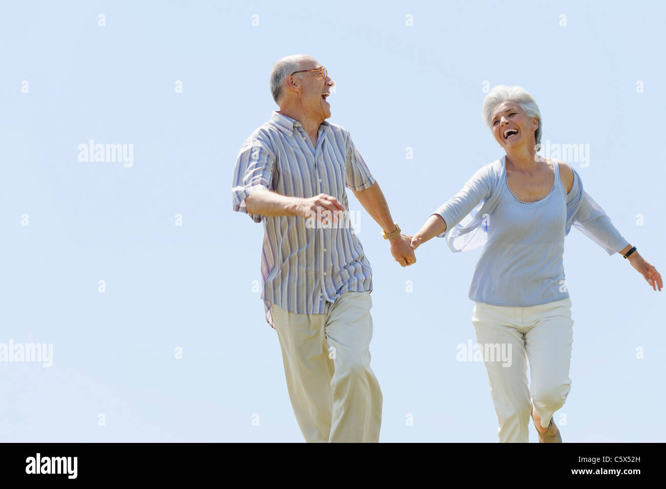 Senior couple running hand in hand hi-res stock photography and images ...