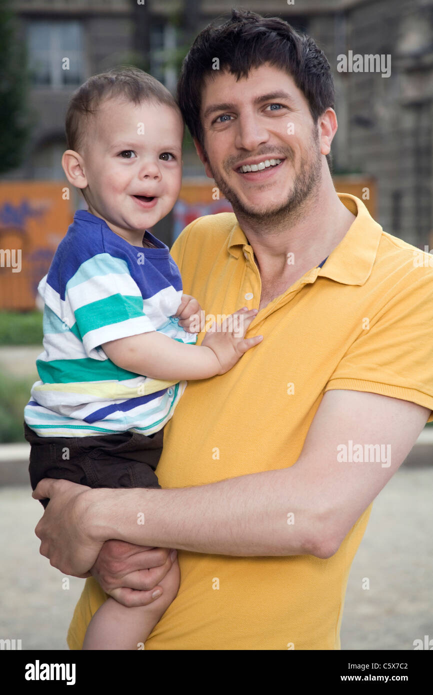 Germany, Berlin, Father holding son (2-3) on his arms, laughing ...