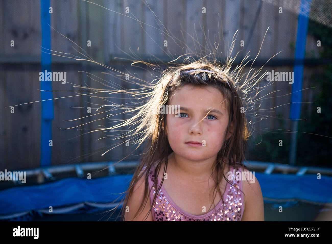 Little girl whose hair has been made to stand up on end by static ...
