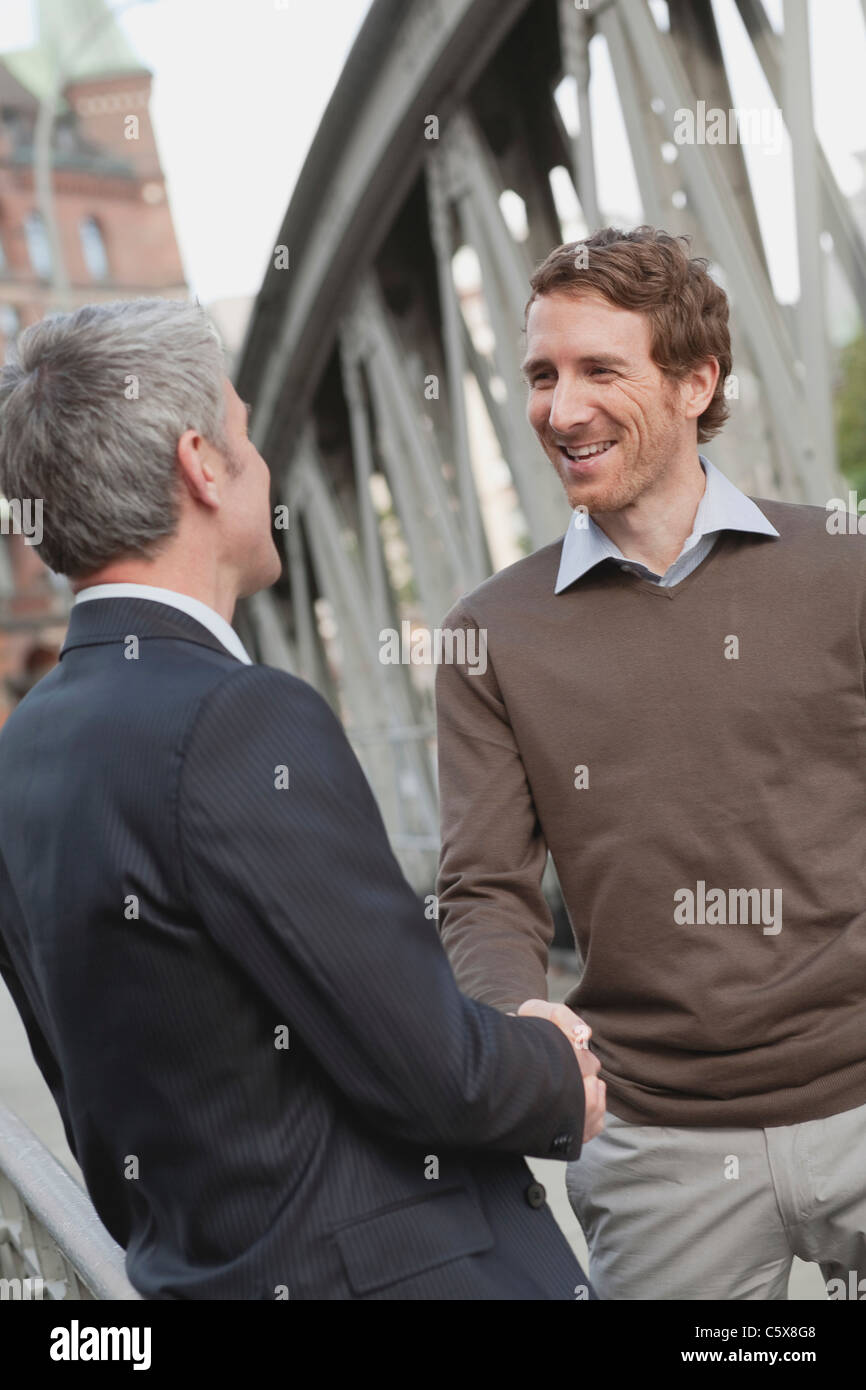 Smiling standing shaking hands face to face communication hi-res stock ...