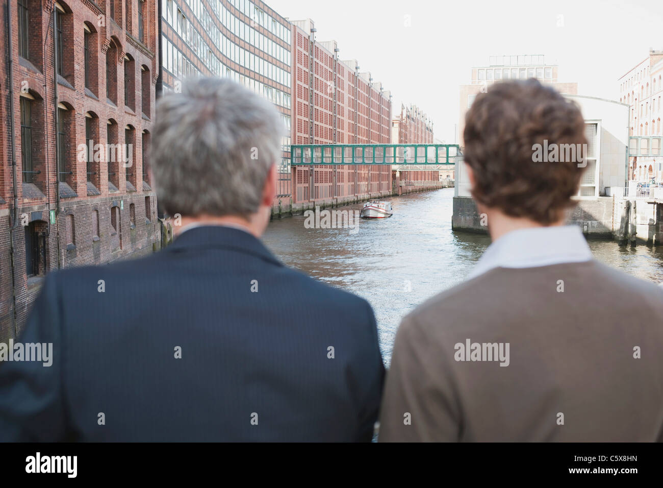 Germany, Hamburg, Two businessmen looking over canal, rear view Stock ...