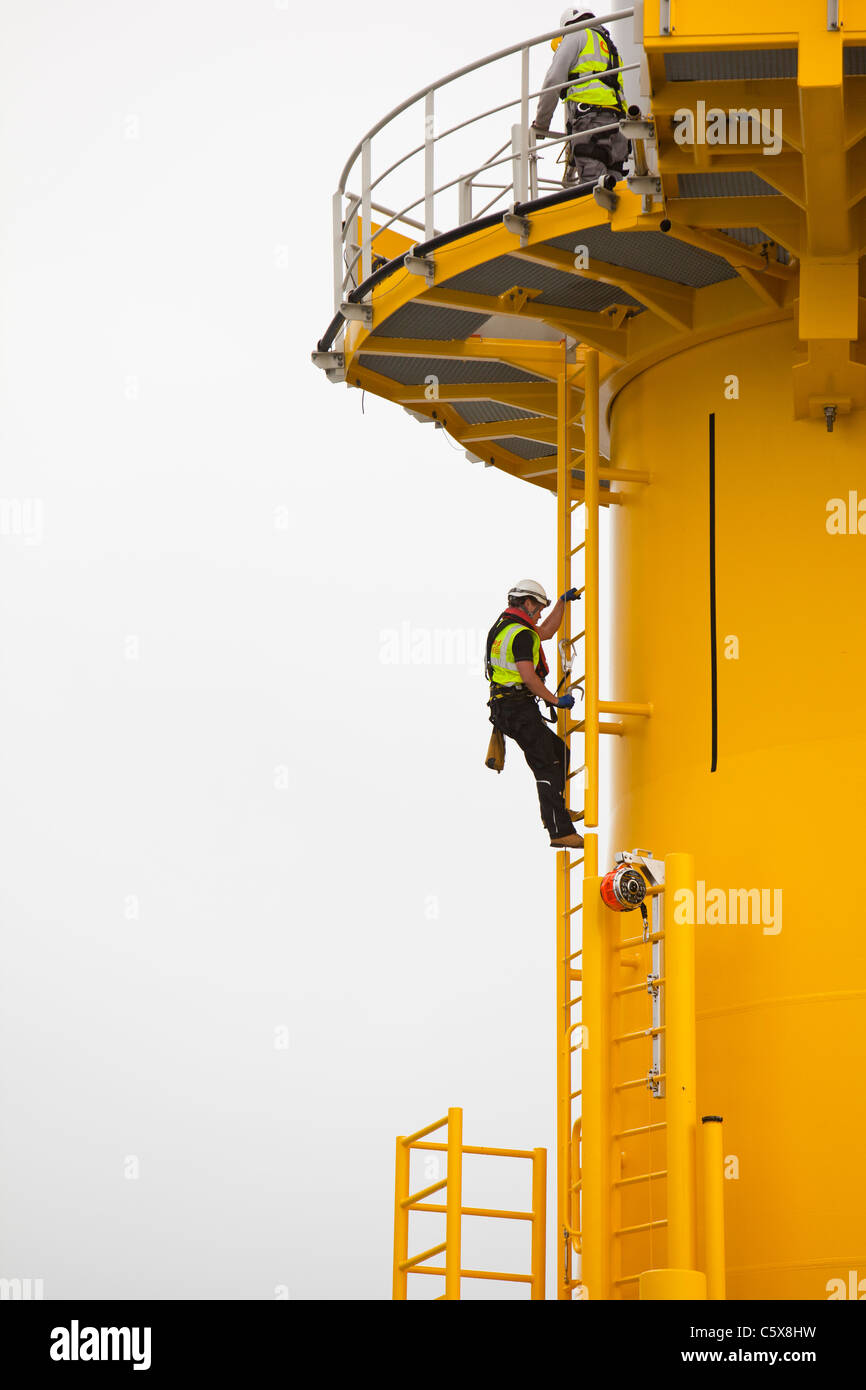 Offshore workers working on a wind turbine at the Walney Offshore ...