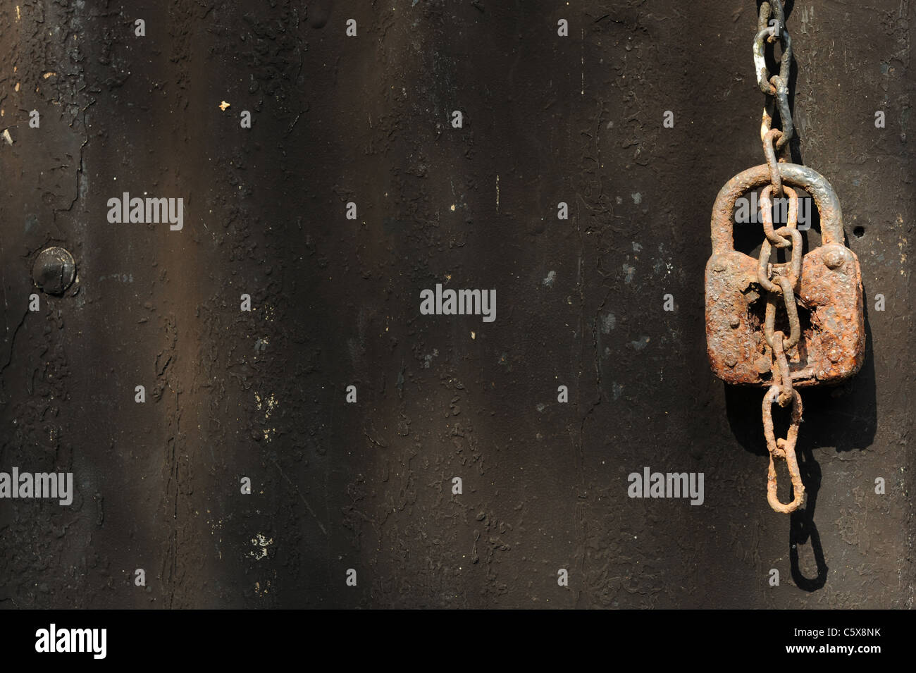 Rusty padlock on a black background Stock Photo - Alamy